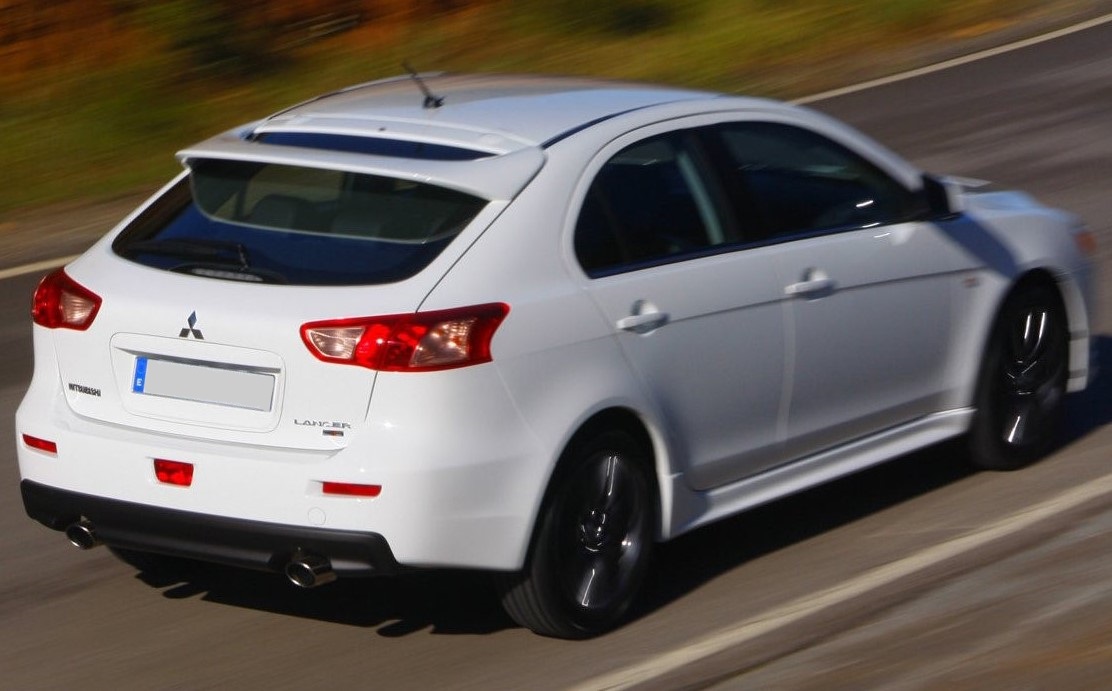 Foto mostrando a traseira de um Mitsubishi Lancer hatch branco que está ...