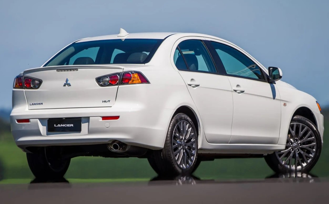 Foto mostrando a traseira de um Mitsubishi Lancer sedan branco que está ...