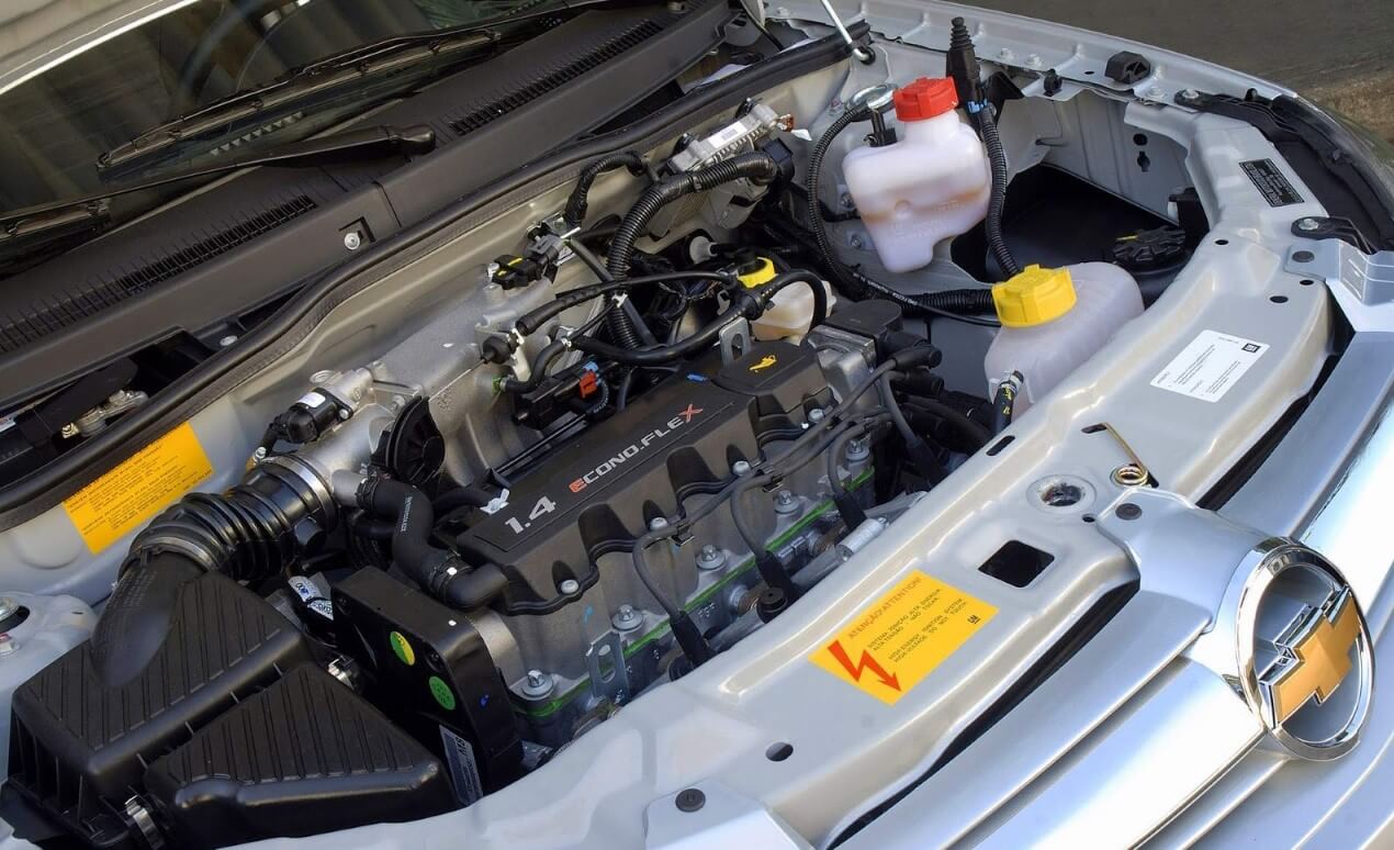 Foto do capô do carro aberto mostrando o motor.