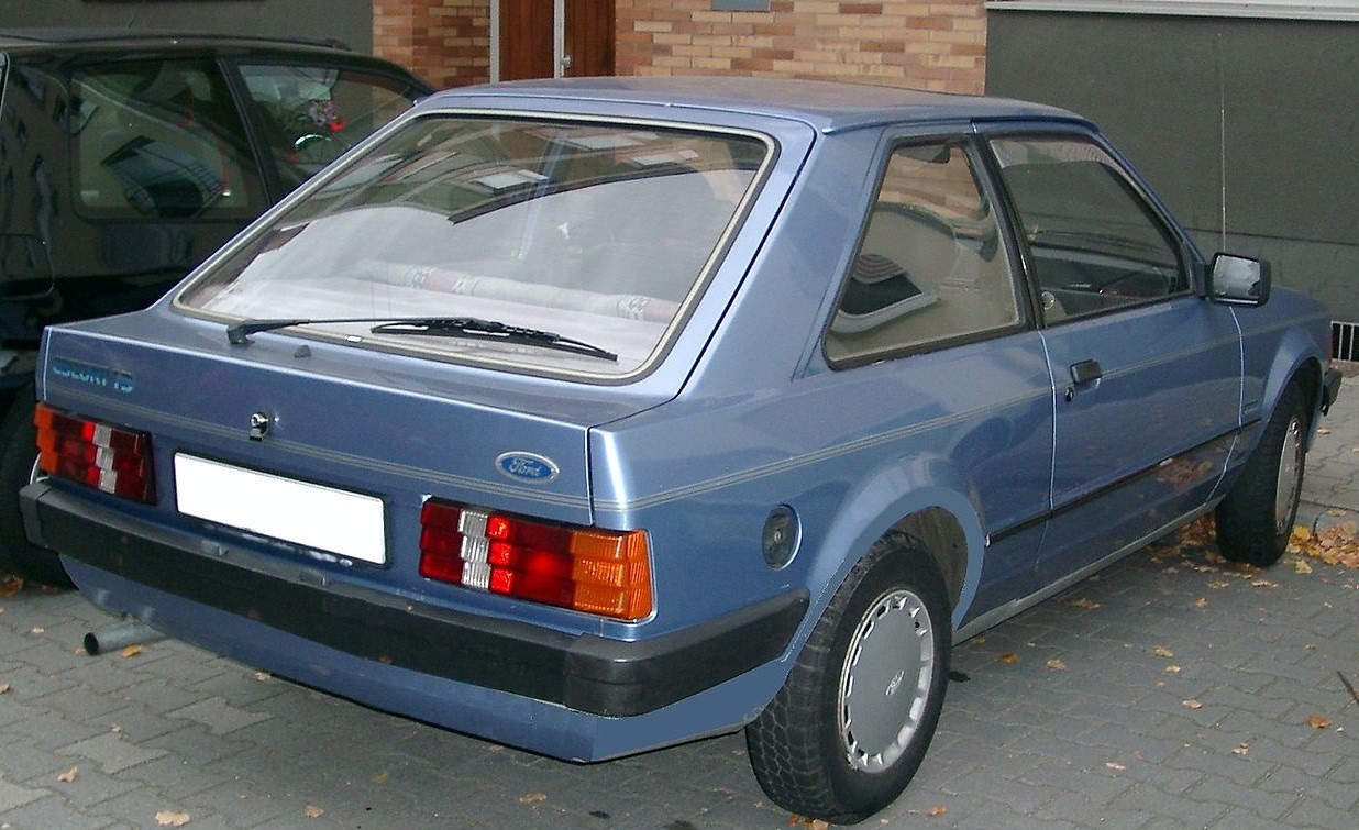 Foto mostrando a traseira de um Ford Escort G1 azul parado em um ...