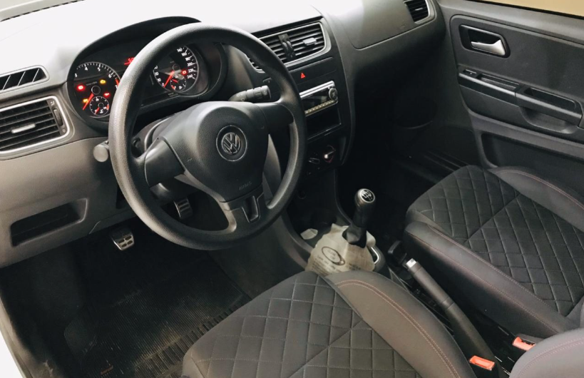 Foto mostrando a cabine do carro. É possível ver o painel, o volante, o ...