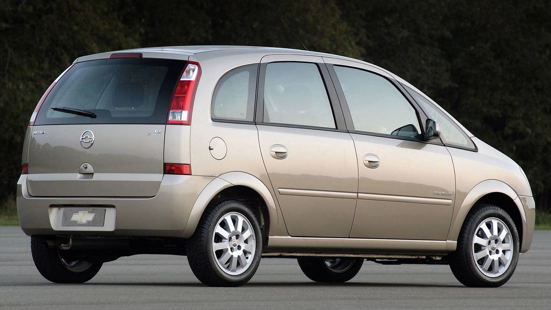 A foto mostra a traseira do Chevrolet Meriva. Ele tem pintura na cor ...