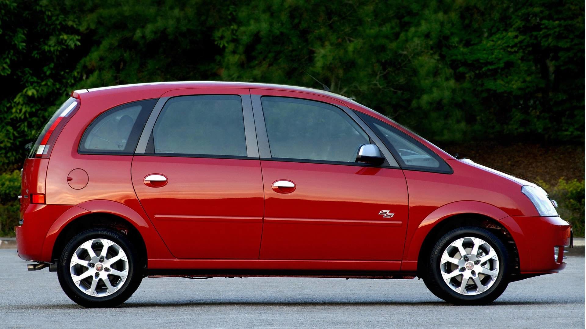 A imagem mostra um Meriva vermelho de lado.