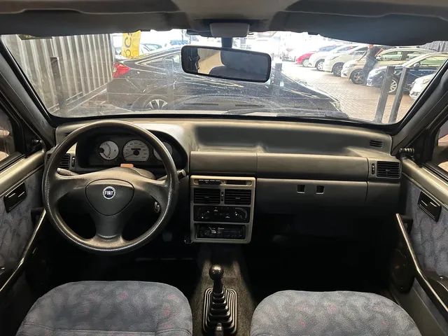 Foto exibindo o interior do carro, o painel e parte das portas e bancos.