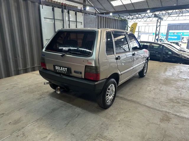 Foto exibindo a traseira e as portas do lado do passageiro do Fiat Uno ...