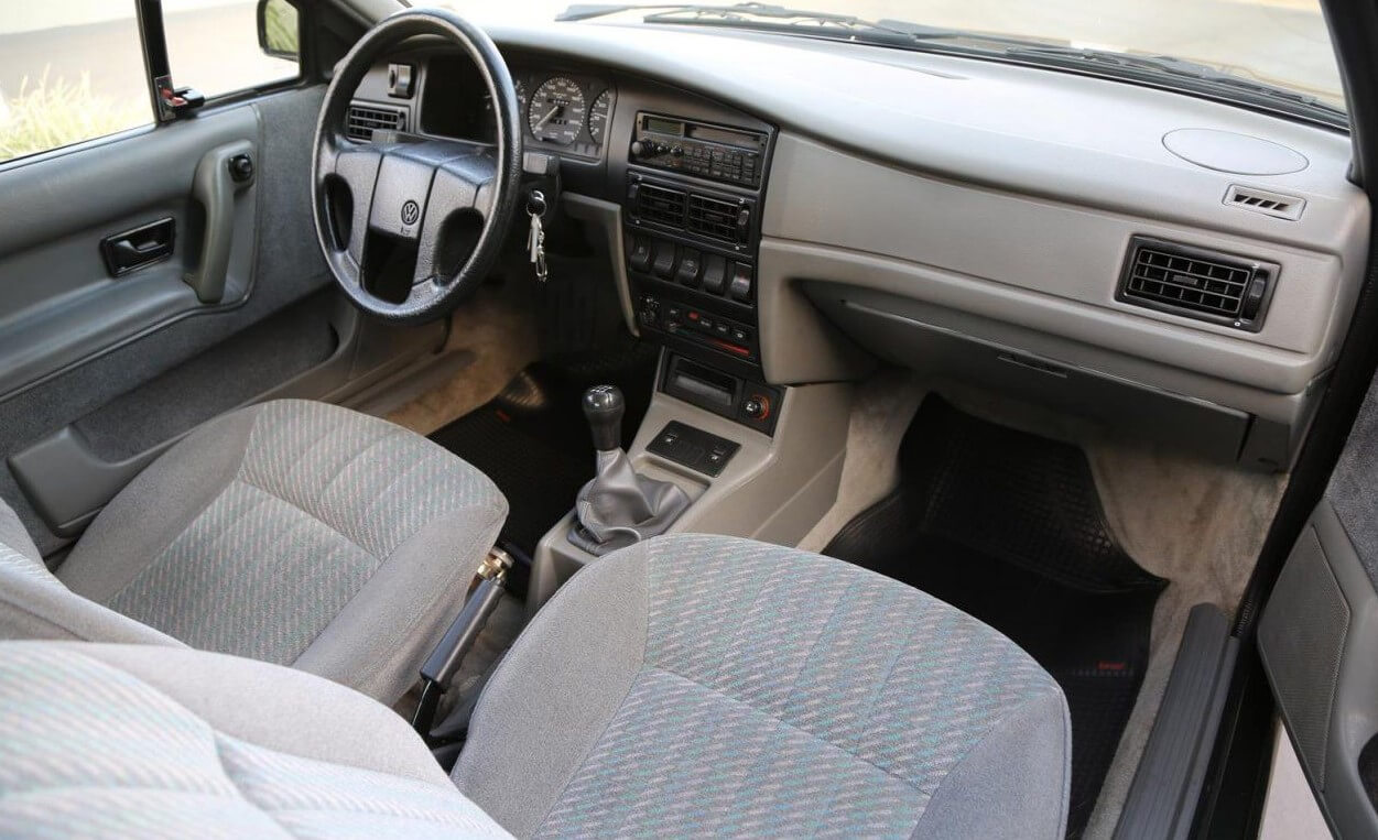 Foto mostrando a cabine do carro. É possível ver o painel, o volante, o ...