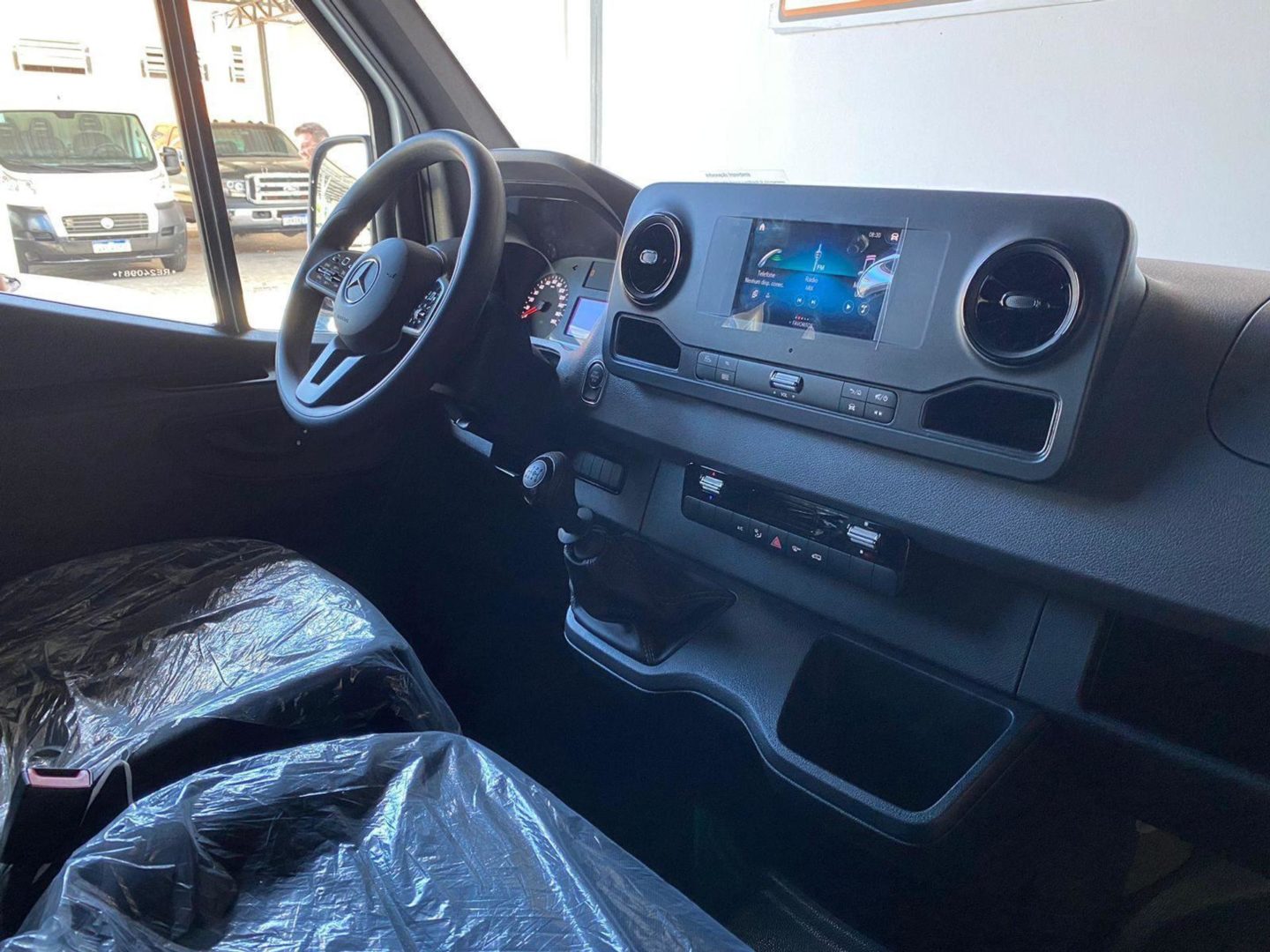 Foto do interior da van, exibindo volante multifuncional, central ...