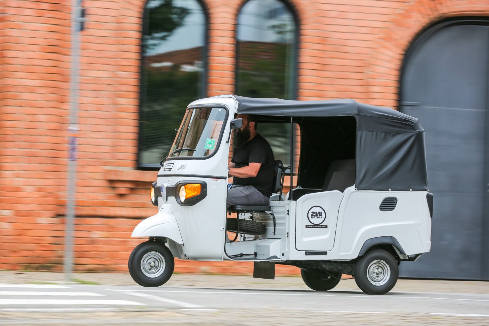 Foto da Piaggio Ape City 2024 de lado andando na rua.