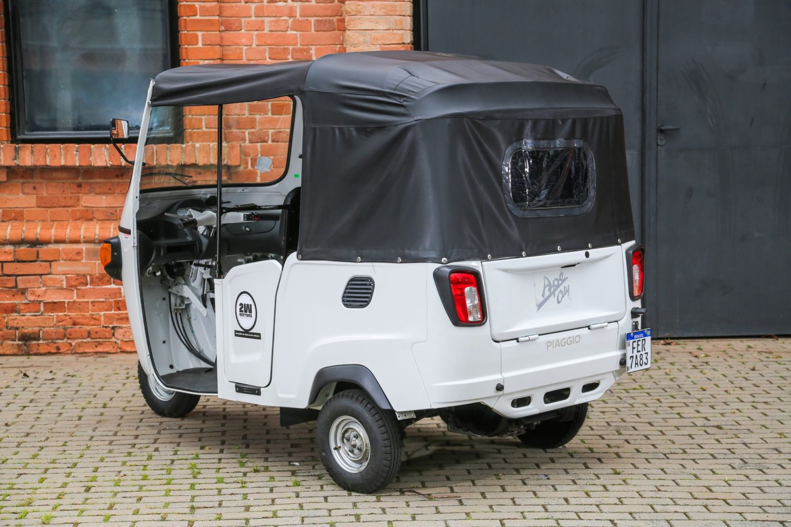 Foto da Piaggio Ape City 2024, exibindo a traseira e a lateral esquerda.