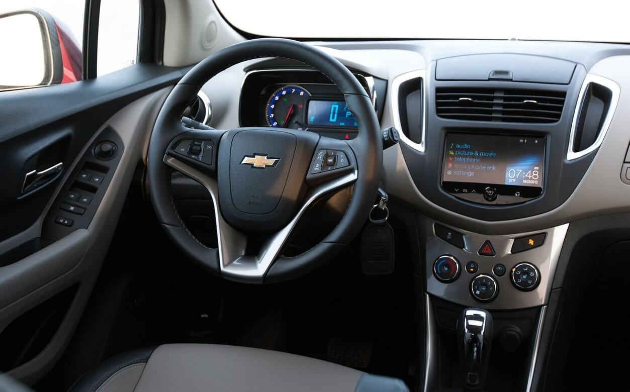 Foto da cabine do carro, mostrando o painel, o volante, uma parte da ...