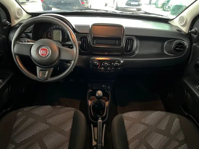 Foto interna do carro, exibindo o painel de instrumentos, o volante, o console central, parte ...