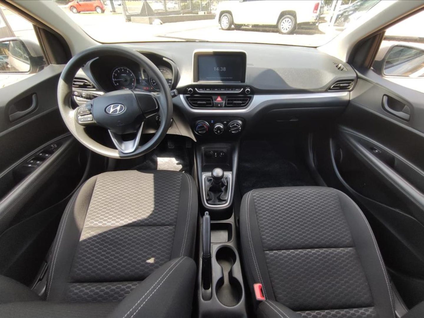 Foto interna do carro, exibindo painel de instrumentos, volante multifuncional, central ...