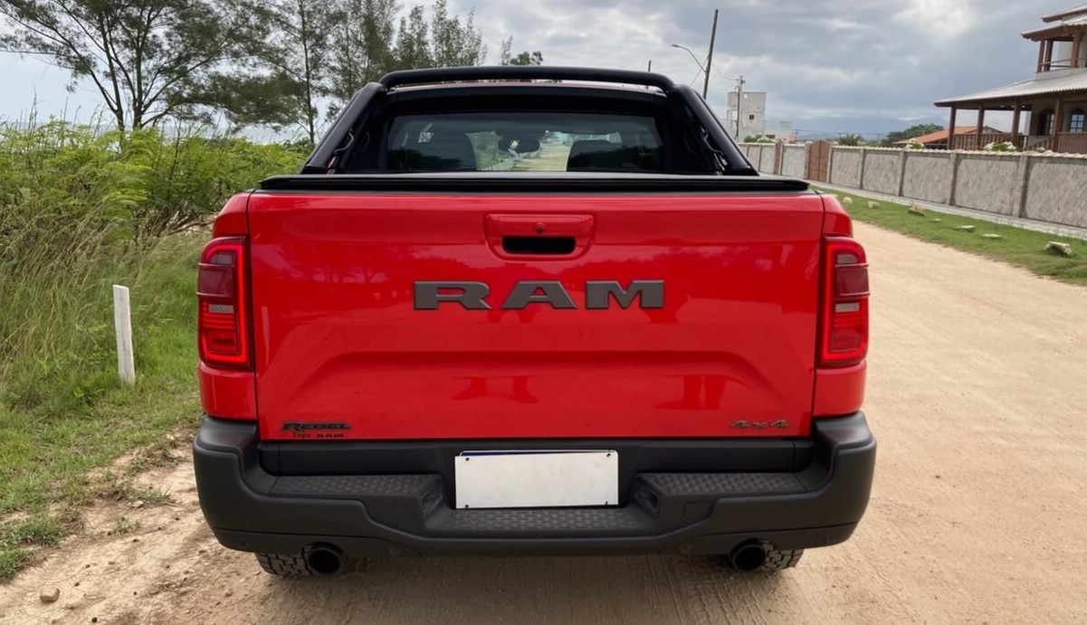 Foto mostrando a traseira de um Novo Ram Rampage vermelho estacionado.