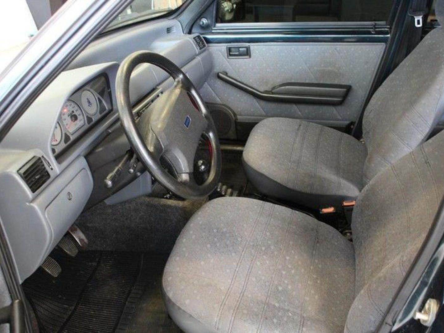 Foto interna do Fiat Uno Mille Smart 2001 exibindo o volante e parte ...