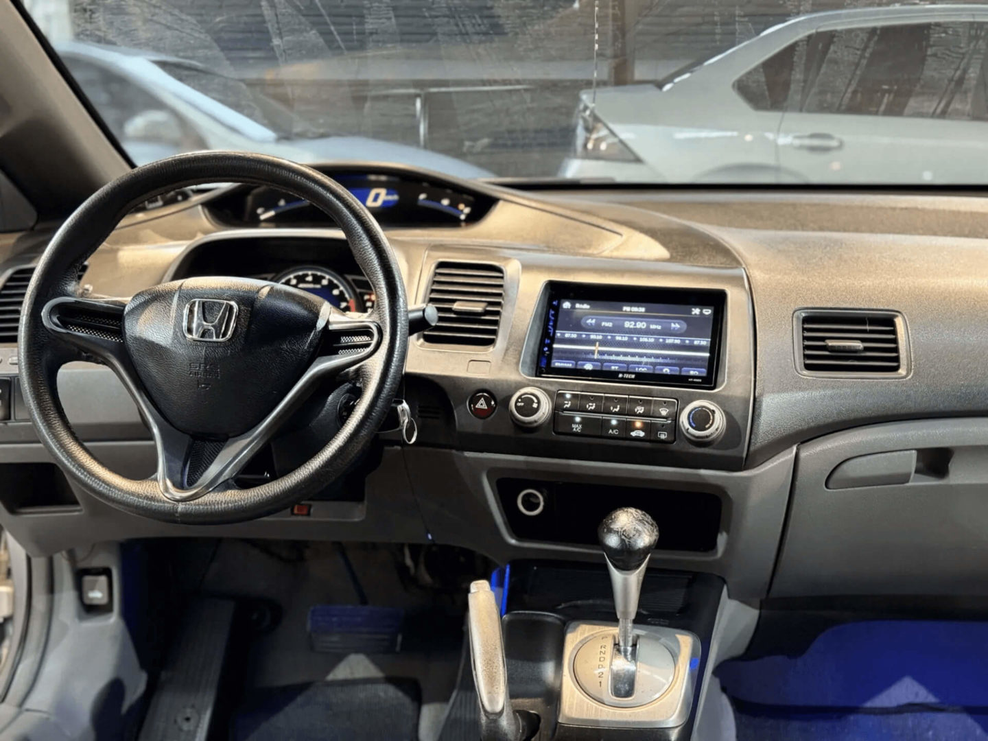 Foto mostrando o painel do carro, o volante e uma parte do console central.