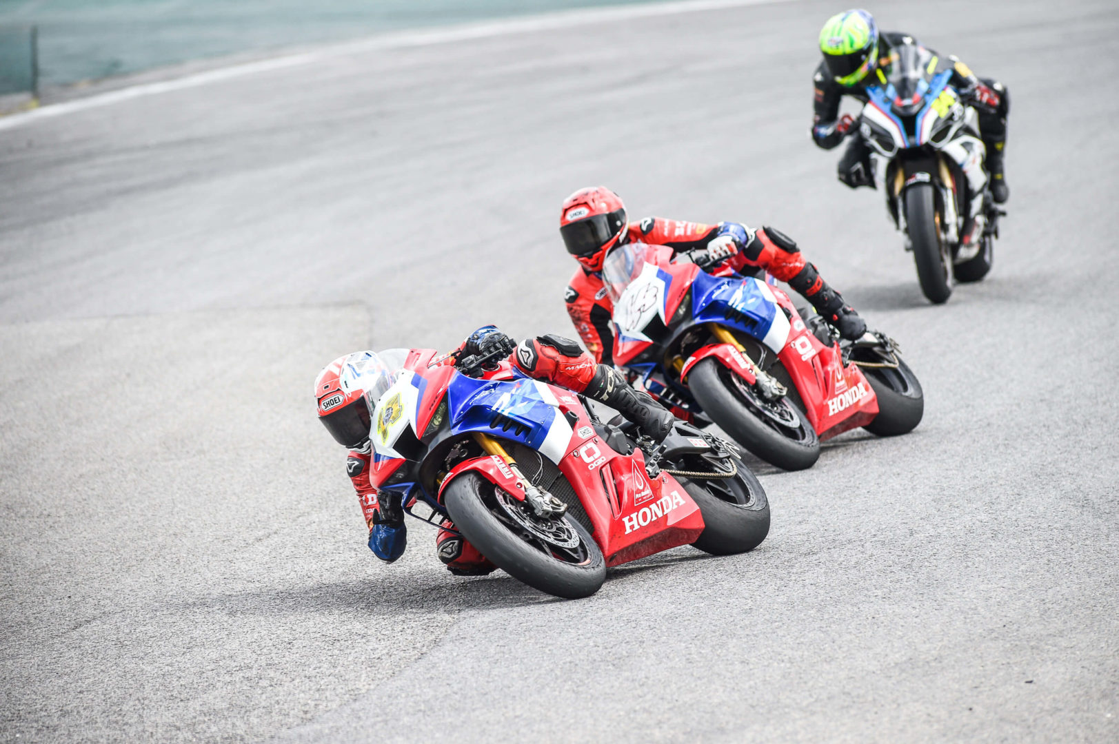 Foto mostrando três pilotos disputando no Superbike.