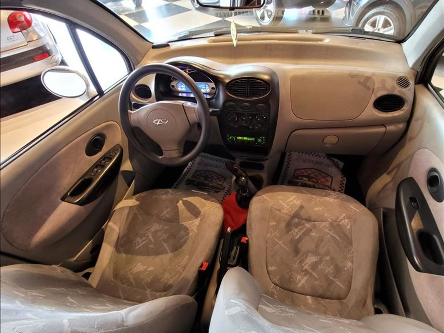 Foto interna do CAOA Chery QQ exibindo o painel de instrumentos digital ...