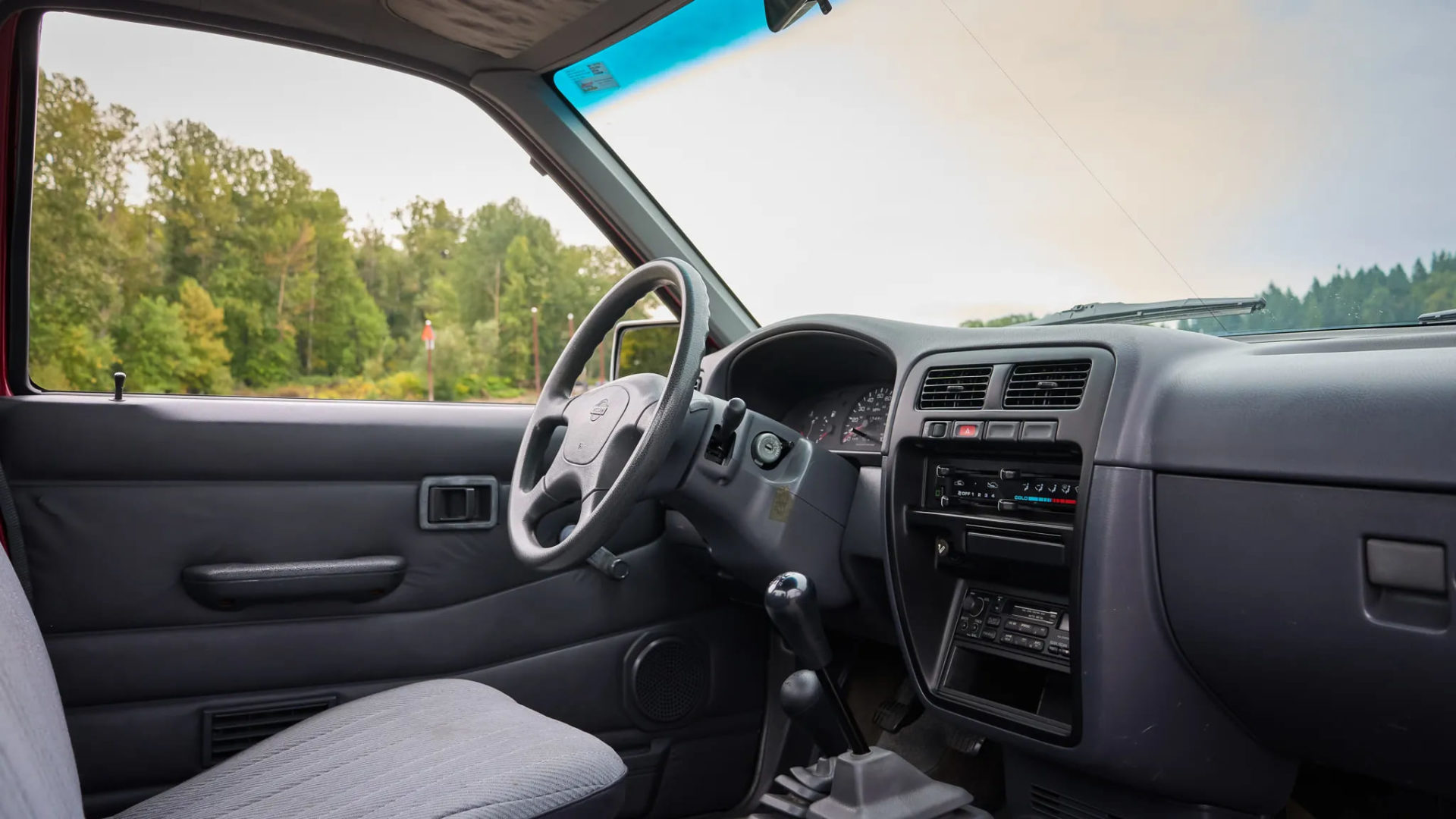 Foto interna da Nissan D21 (1993-1997), exibindo parte do cockpit da ...